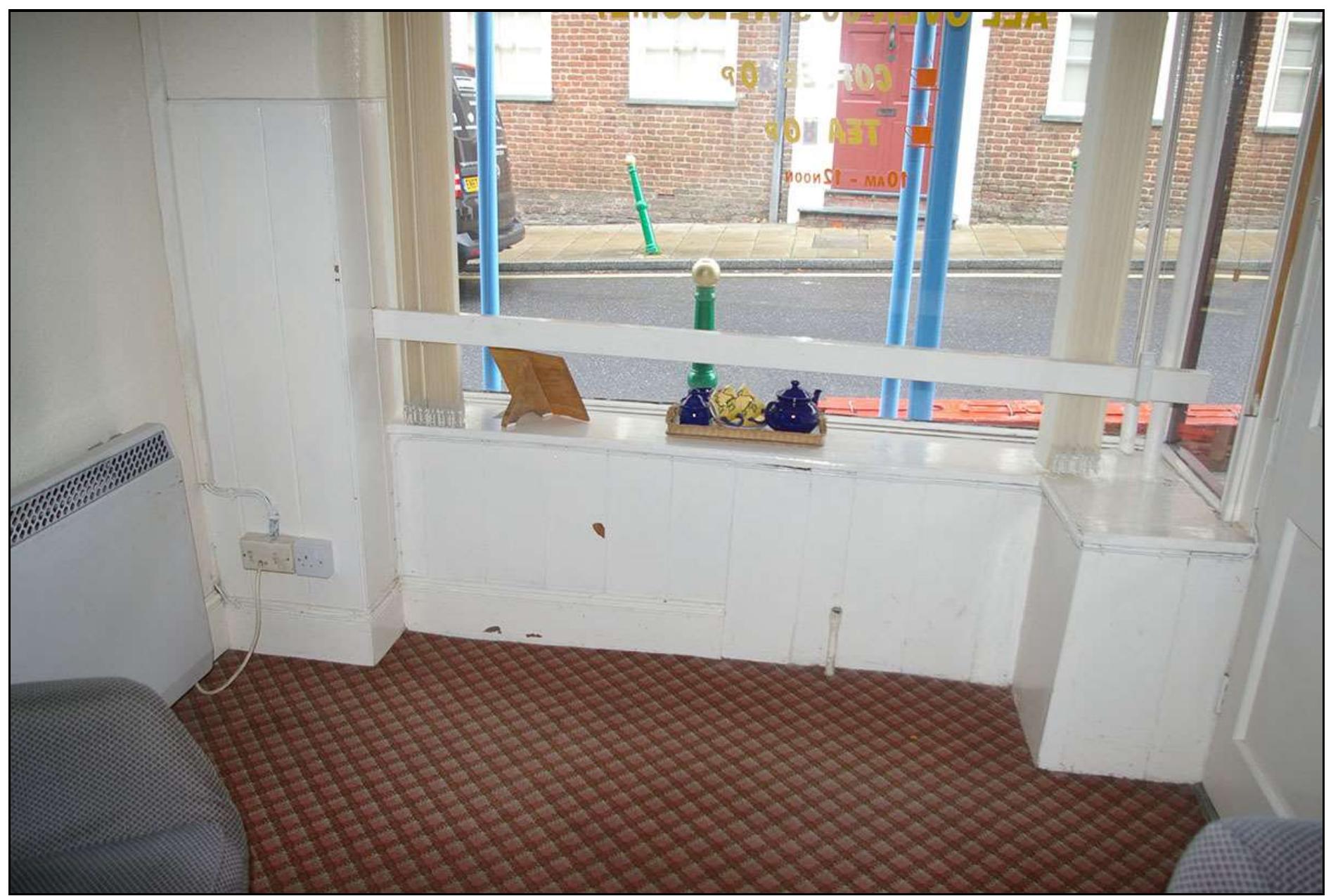 16. the surviving beaded plank panelling under window and to