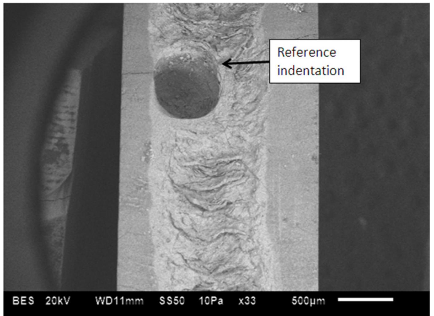 Sample with a reference indentation for location of the area