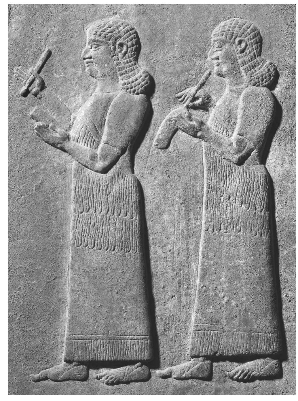 8 two neo-assyrian scribes, one holding a clay tablet and