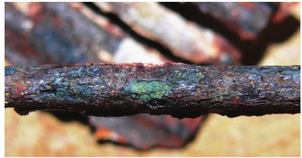 Prestressing strand with corrosion products including