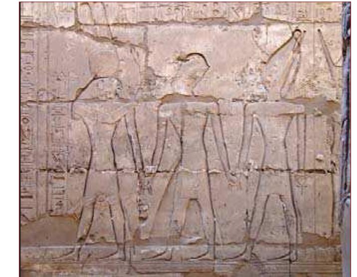 Ramesses ii (center) holds the hands of the gods montu
