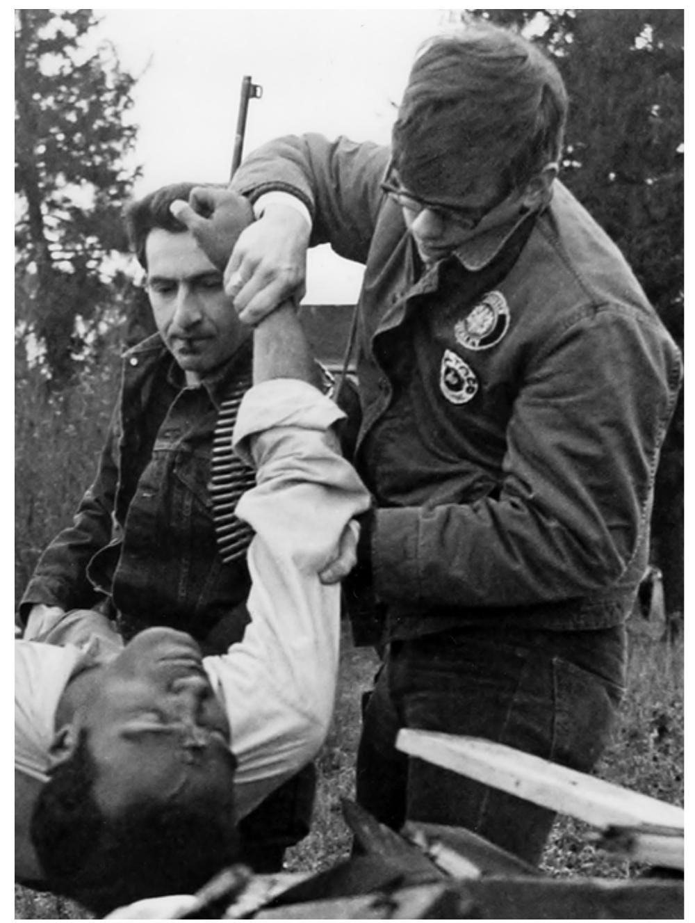 The authorities drag the dead body of ben to the zombie pyre