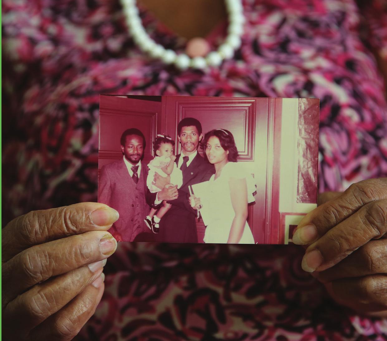 The mother of conrad holds a photograph of her son with