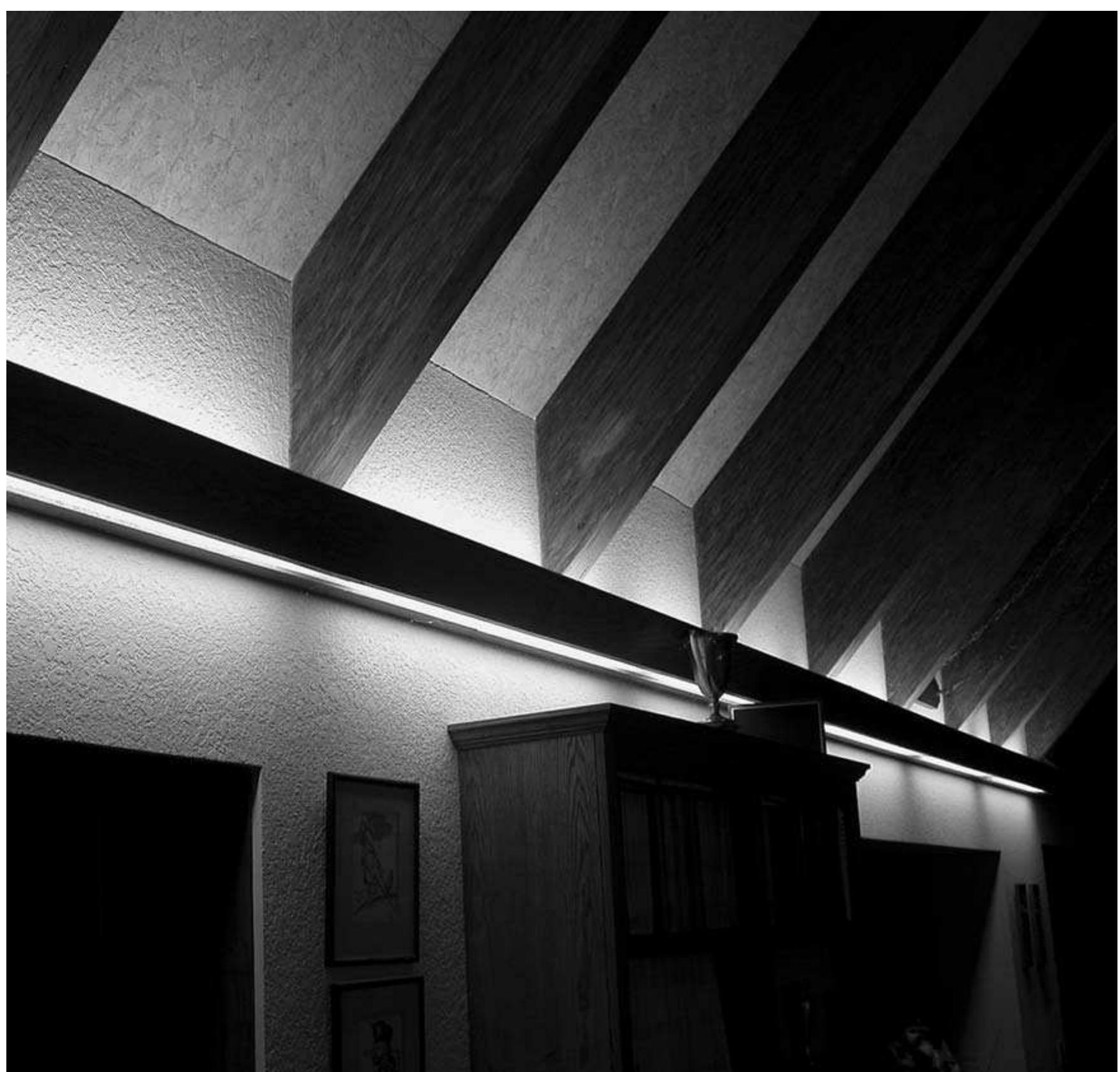 13 photograph showing soffit lighting of ceiling rafters.
