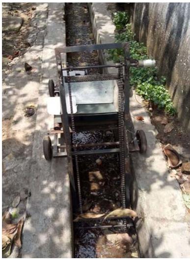 The robot is cleaning a drain.